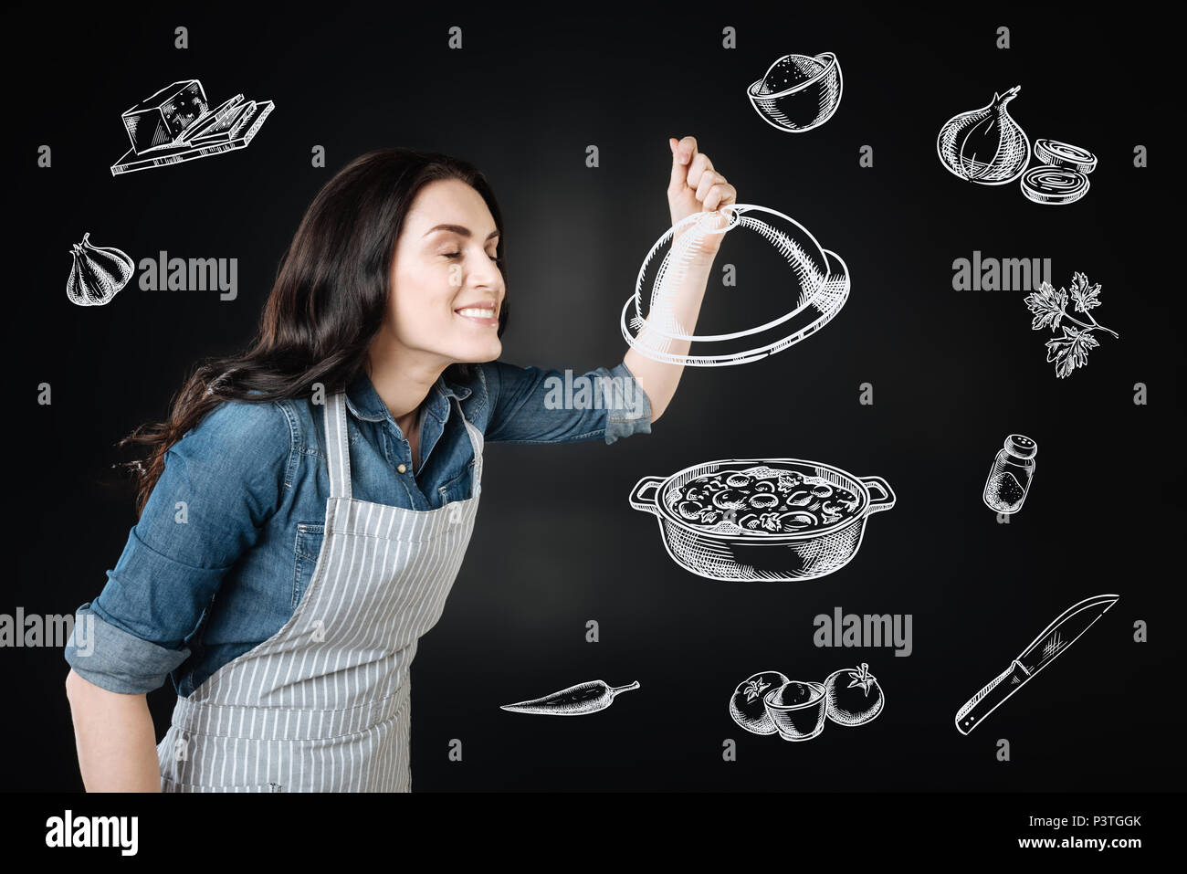 Happy cook closing her eyes while smelling the dish Stock Photo - Alamy
