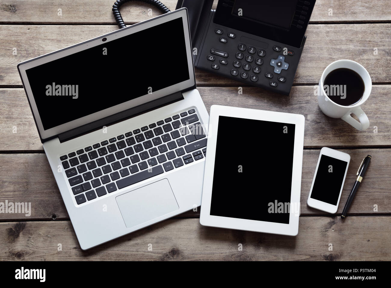 Open laptop with white digital tablet and smartphone on desk from above ...