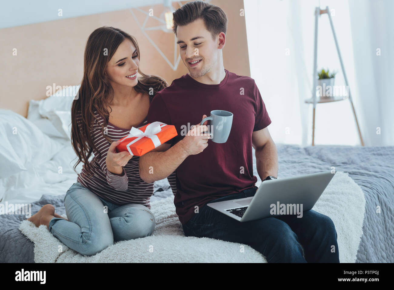 Joyful nice woman giving a present Stock Photo - Alamy