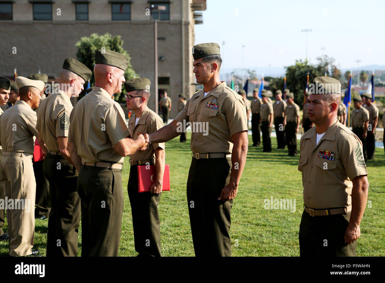 U.S. Marine Brig. Gen. David A. Ottignon greets and presents the Marine ...