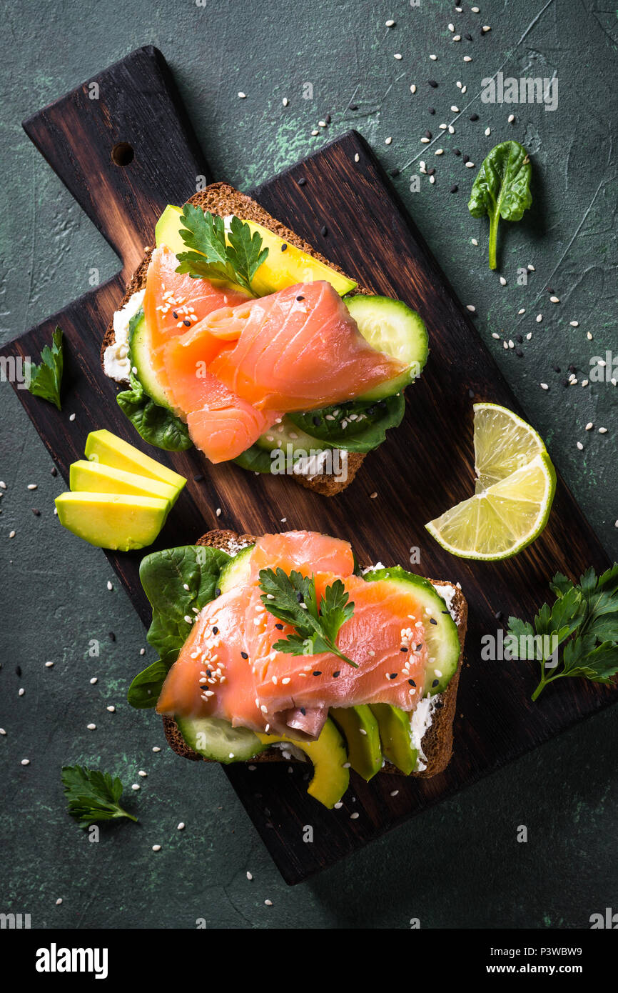 Open sandwich or toast. Grain bread with salmon, white cheese, avocado ...