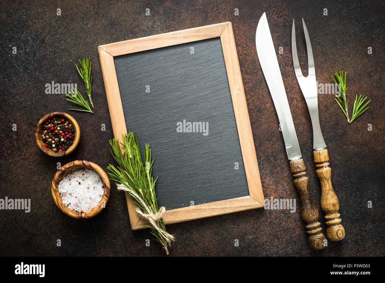 Food background. Fork, knife, spices and seasoning on rusty stone table ...