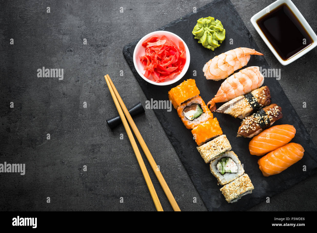 Sushi and sushi roll set on black stone table top view with copy space ...