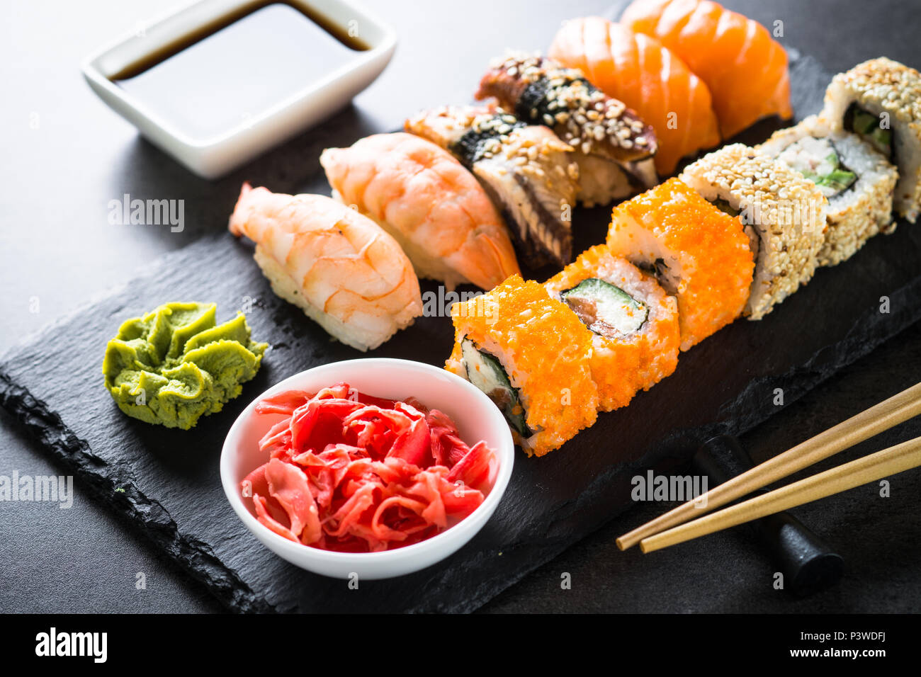 Sushi and sushi roll set on black stone table. Traditional asian food ...
