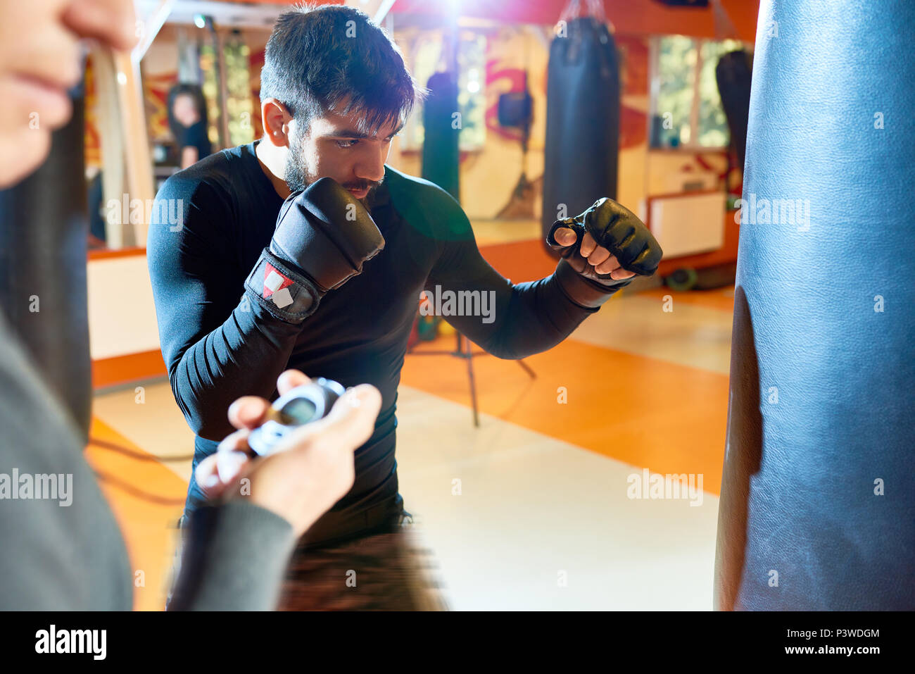 Boxer training with coach setting timer Stock Photo - Alamy