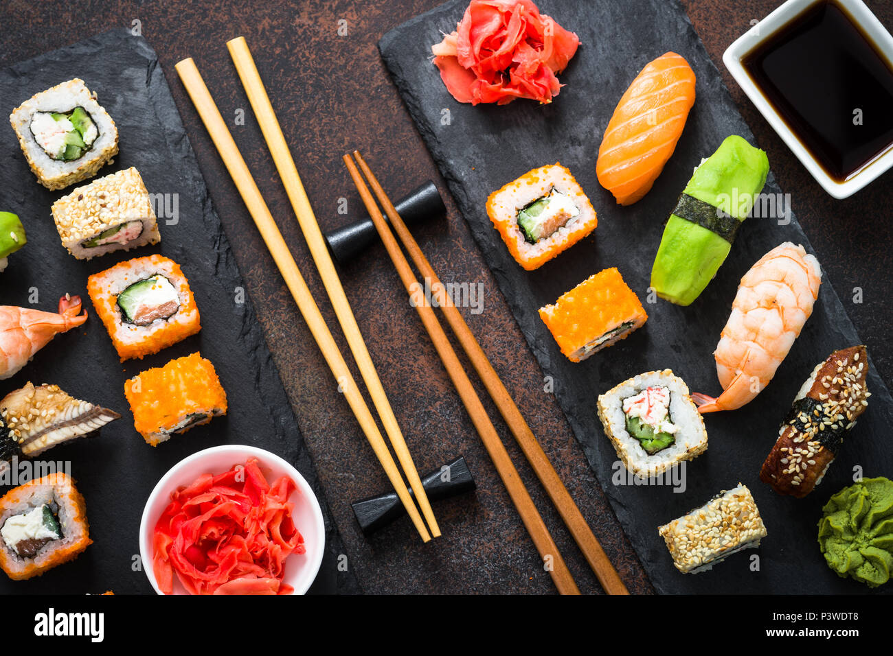 Sushi, maki, nigiri and sushi roll set on dark stone table top view ...