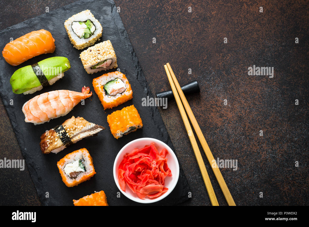 Sushi and sushi roll set on dark stone table top view with copy space ...