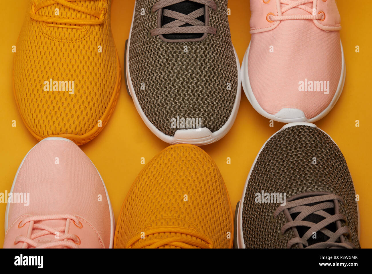 Set of sport colorful shoes on yellow background Stock Photo - Alamy
