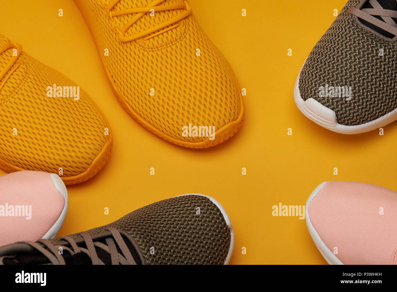 Colorful sport shoes stay on yellow background close up view Stock ...