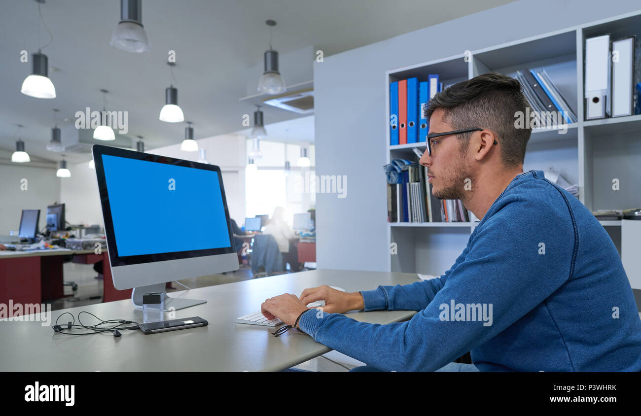 Designer young man working with computer at indoor company office Stock ...