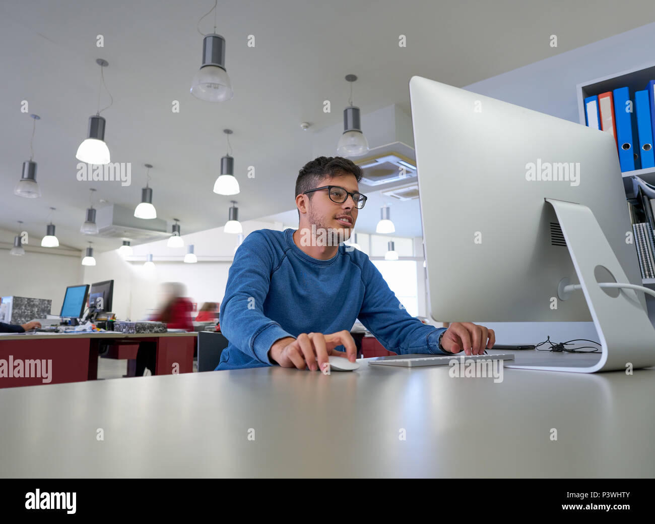 Designer young man working with computer at indoor company office Stock ...