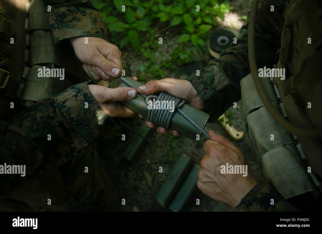 U.S. Marine combat engineers tie a knot in detonation cord before ...