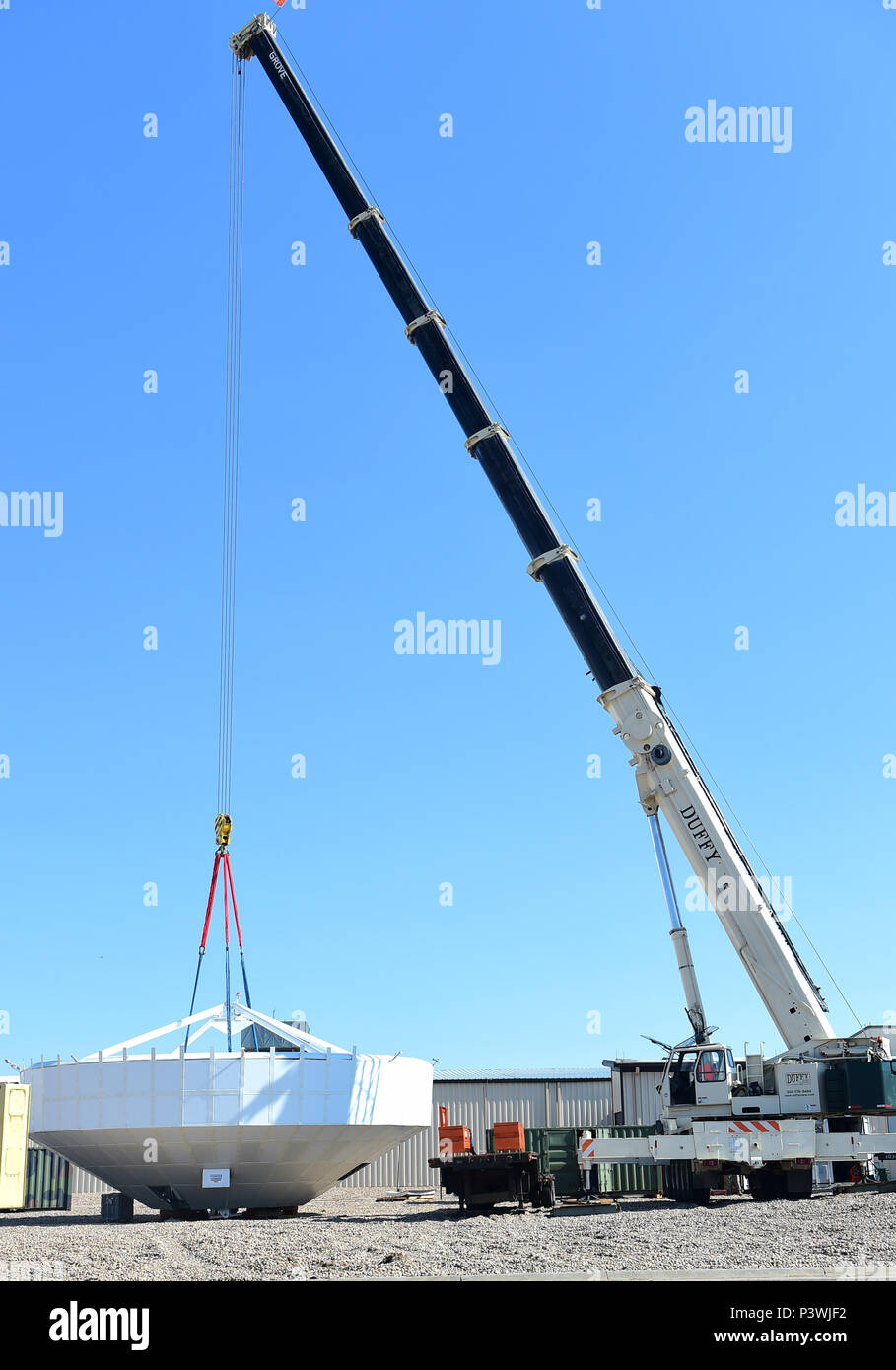 A construction crew works on a radome as part of a multi-step project ...