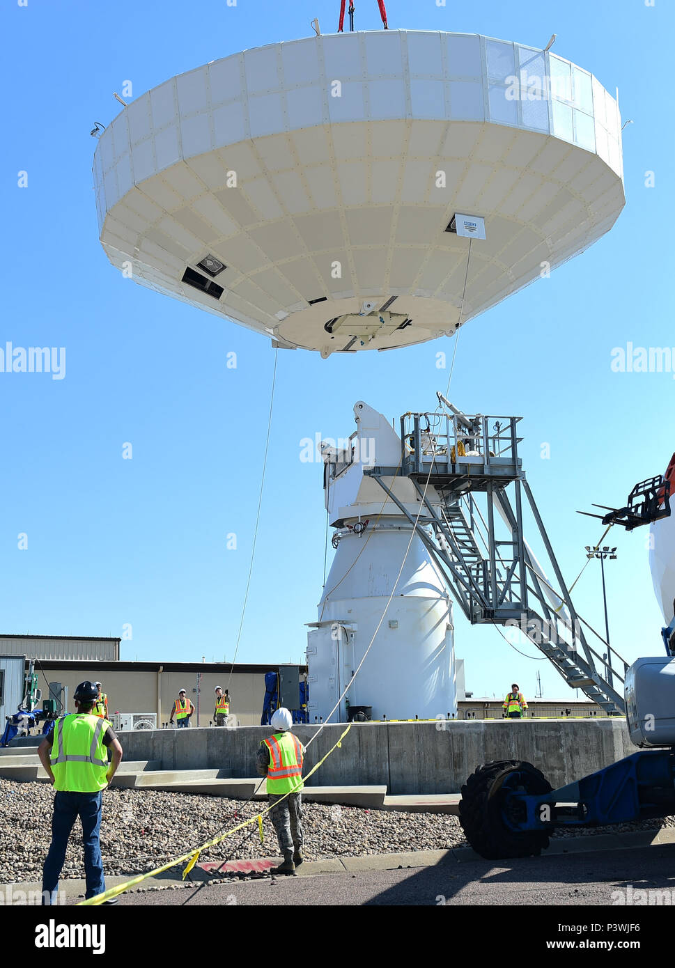 A construction crew works on a radome as part of a multi-step project ...
