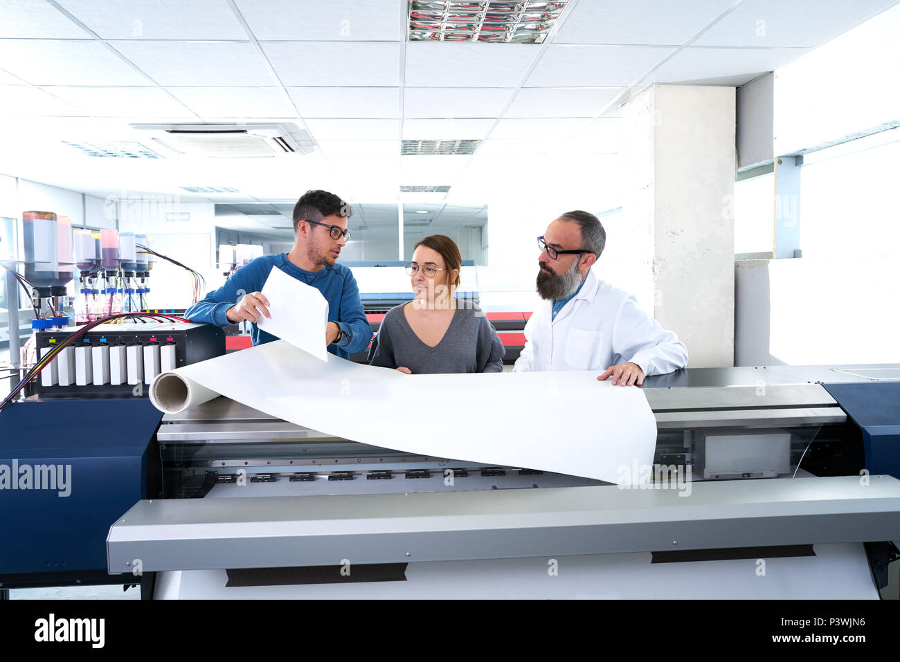 Printing team at industry plotter printer men and woman Stock Photo - Alamy