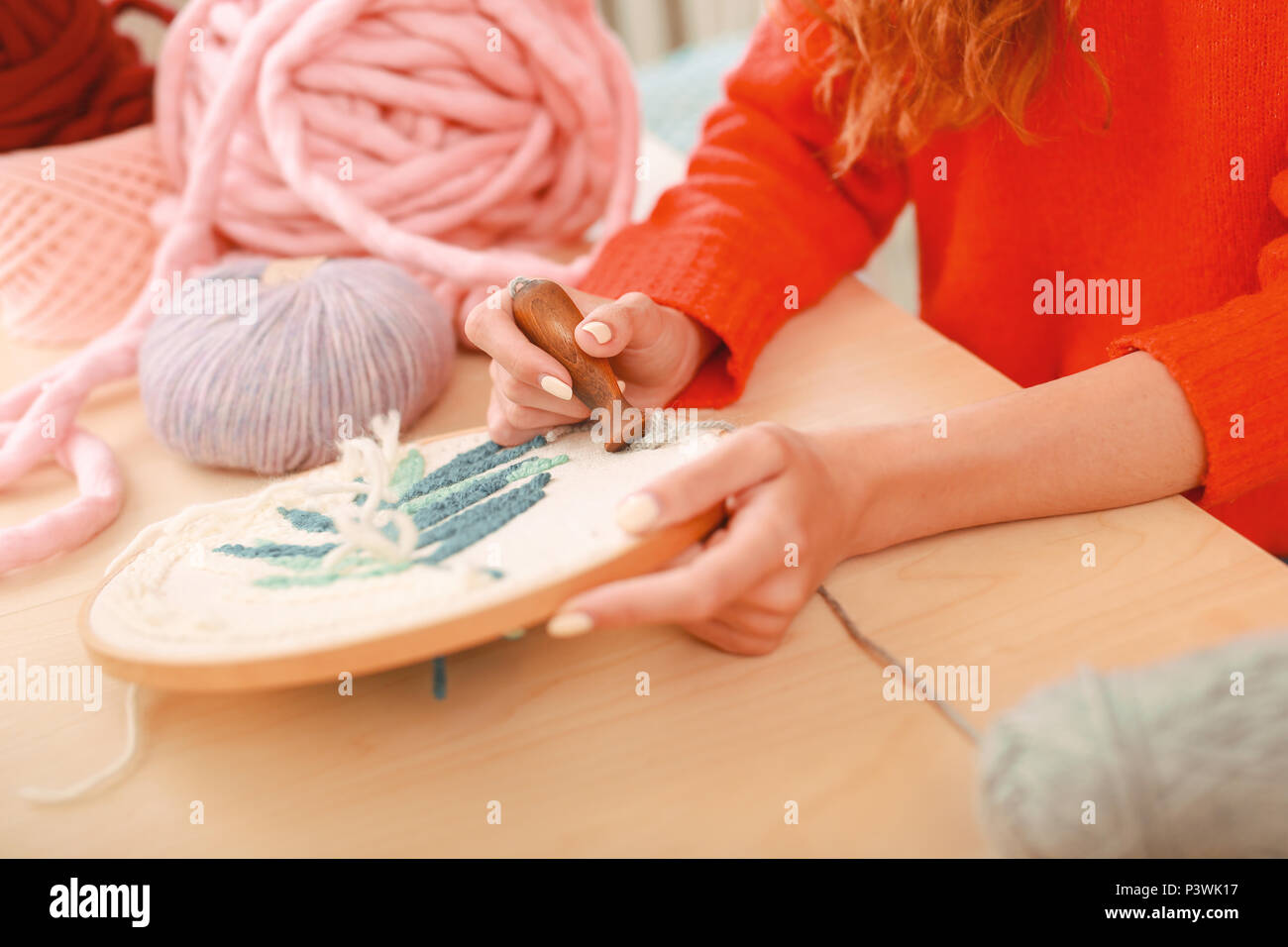 Creative woman stitching picture for decorating home Stock Photo - Alamy