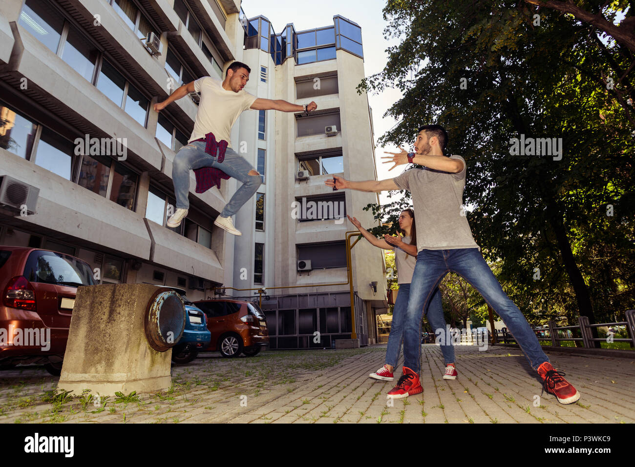 Three friends is having fun while one guy is jumping from wall Stock ...