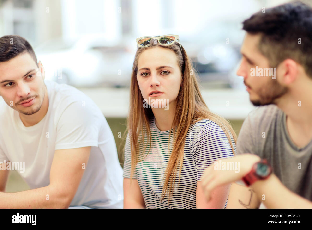 Group of three cheerful friends while sitting on summer time Stock ...