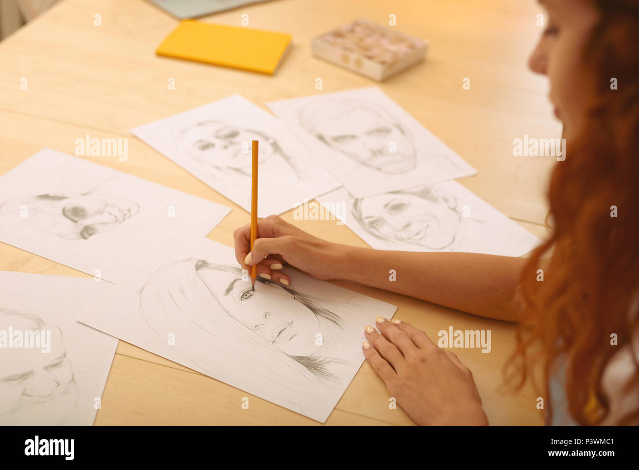 Red-haired creative person drawing caricatures Stock Photo - Alamy