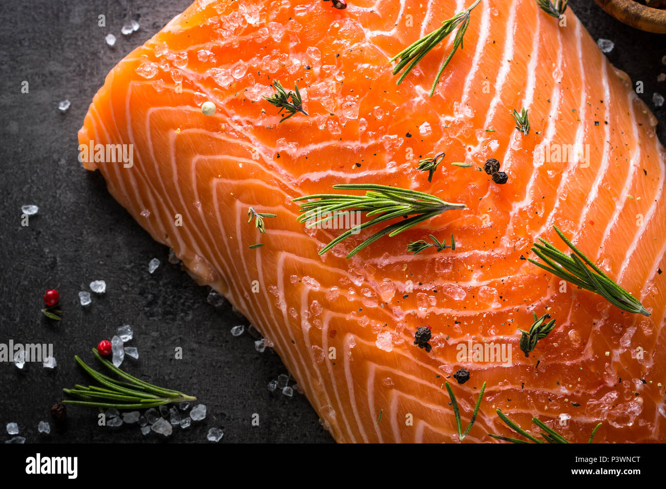 Fresh fish. Salmon uncooked fillet on black slate table. Top view copy ...