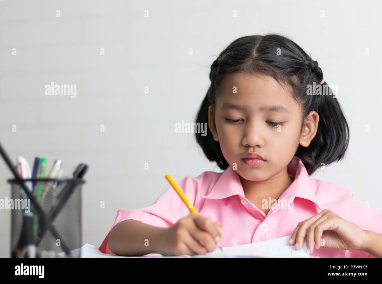 Close up the little girl is doing homework intently. Children use a ...