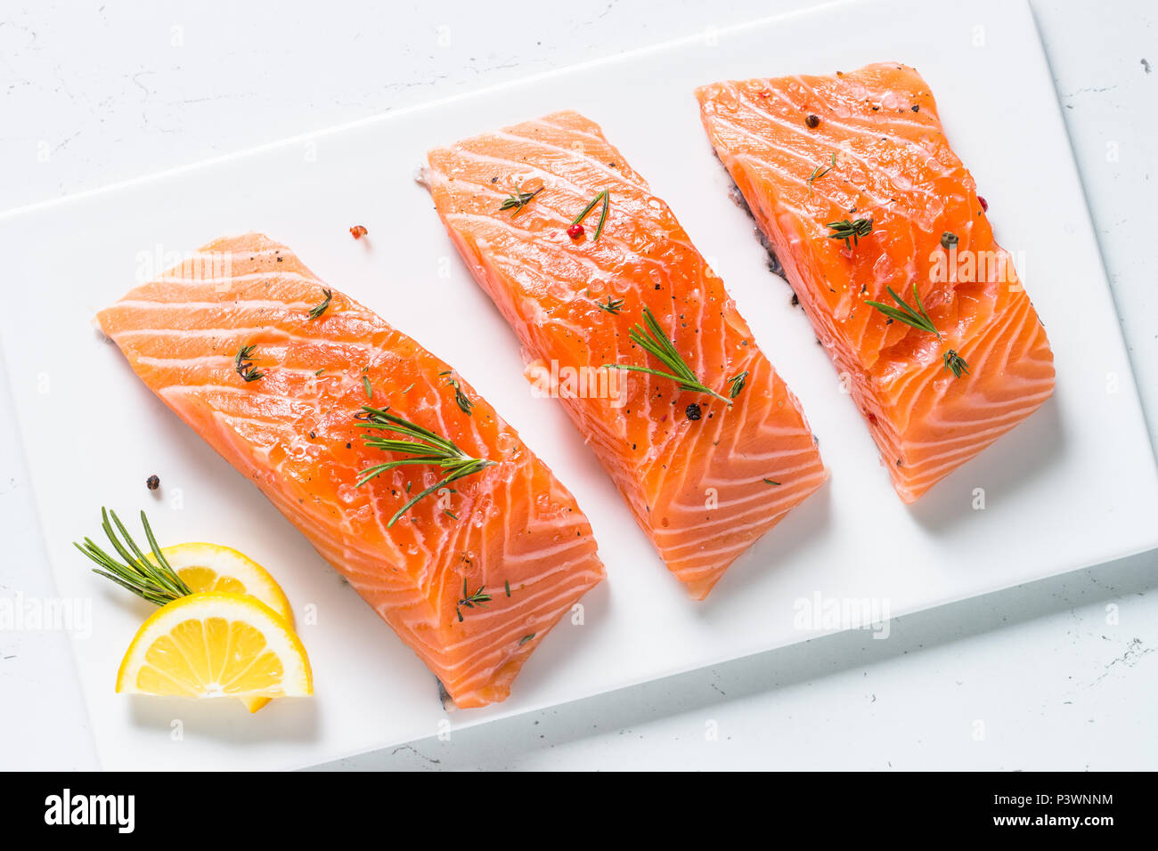 Fresh fish. Salmon uncooked fillet with lemon sea salt and rosemary on ...