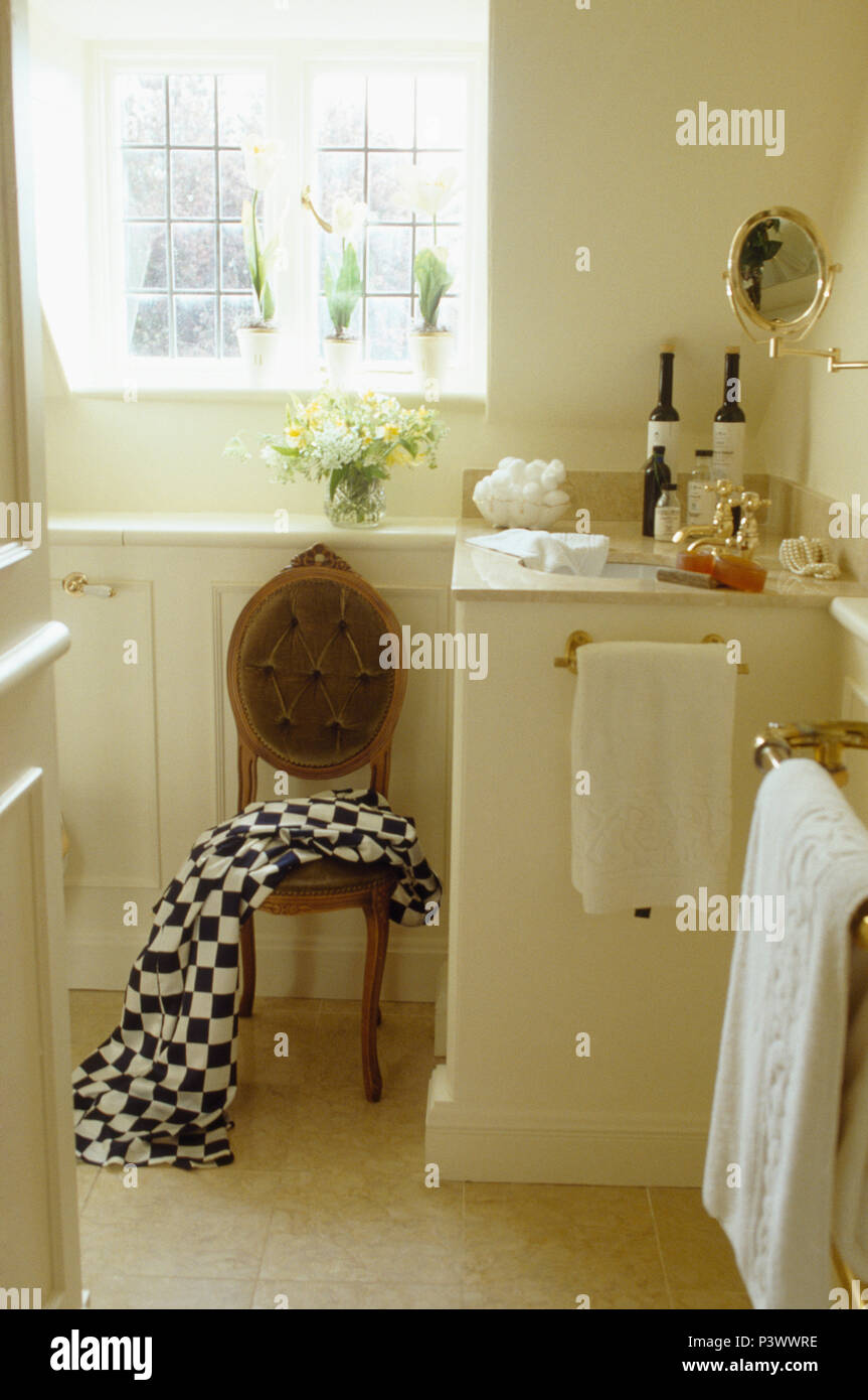 Black+white chequerboard towel on antique chair beside basin in vanity ...