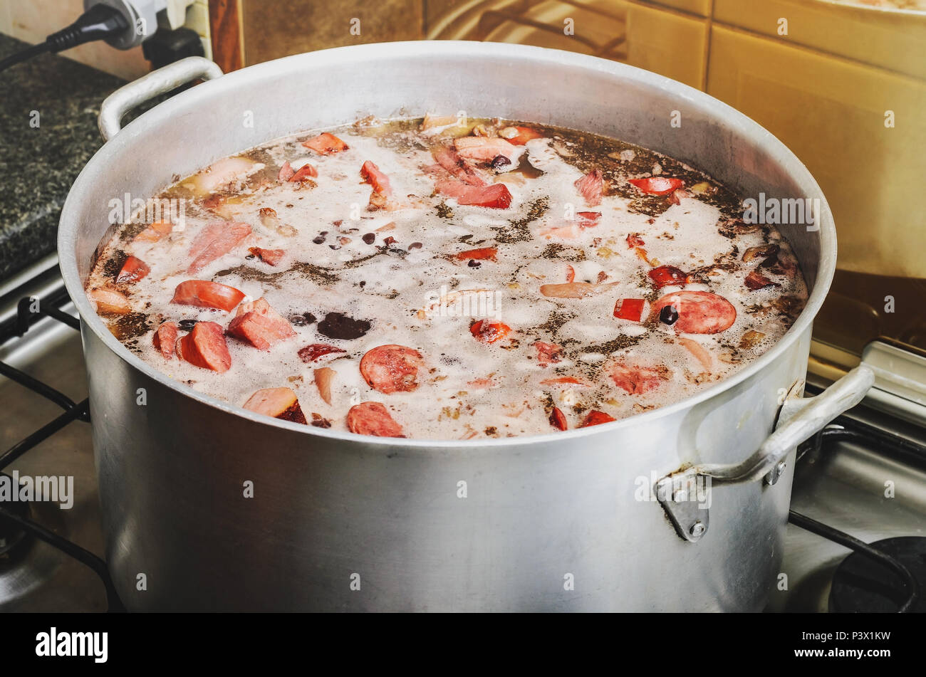 Cooking a big pan of Feijoada. Typical Brazilian cuisine, Feijoada has ...