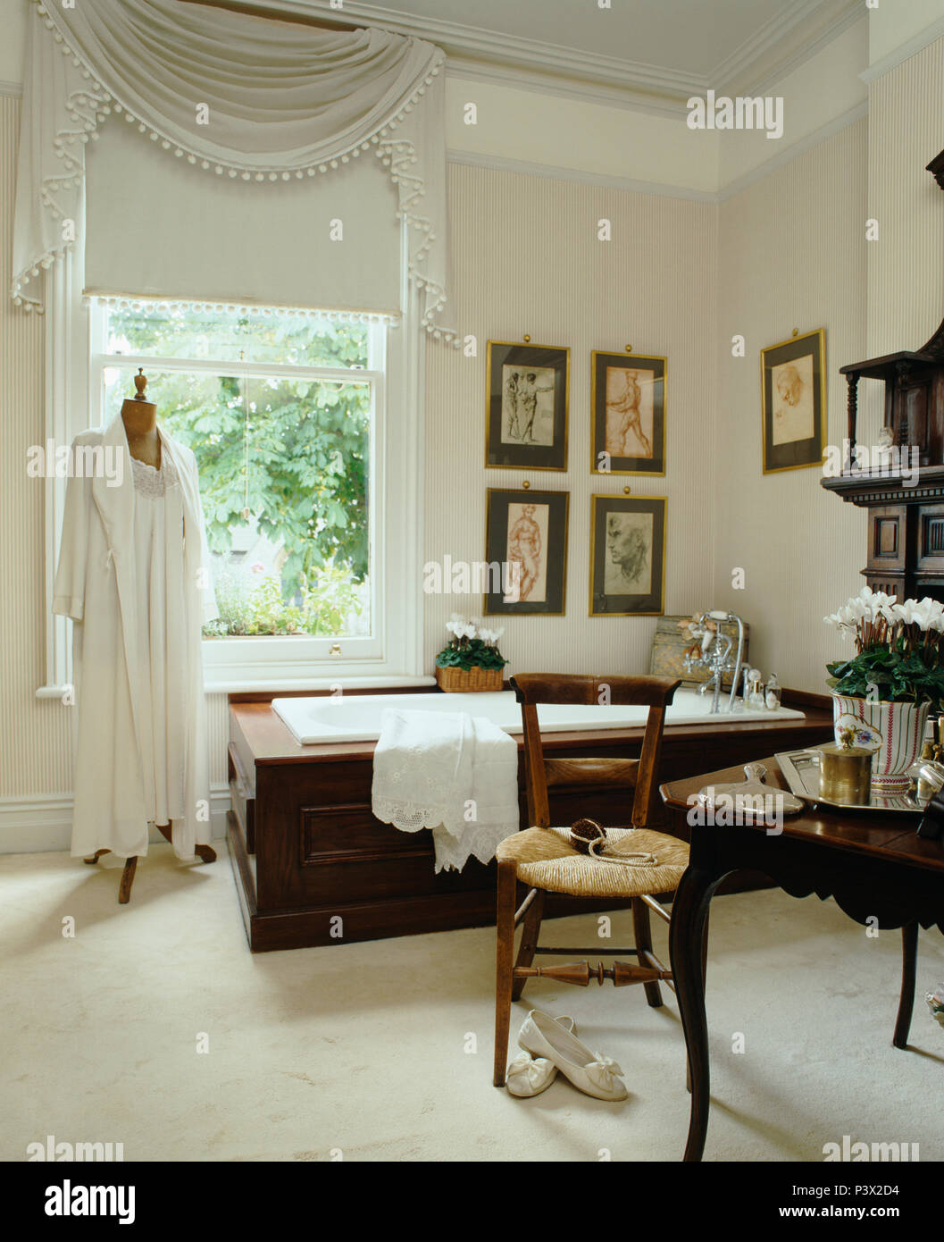 Draped white fabric and white blind on window in bathroom with ...