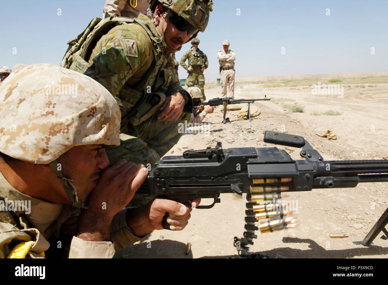An Australian coalition trainer observes an Iraqi soldier firing a ...