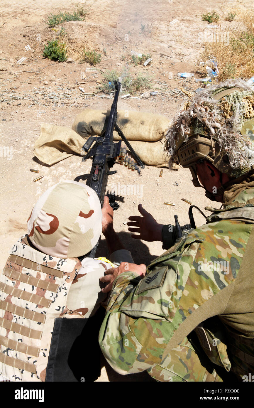 An Australian coalition trainer observes an Iraqi soldier firing a ...
