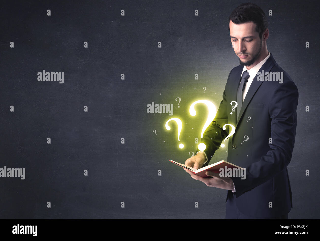 Businessman holding a book with question mark symbol Stock Photo - Alamy