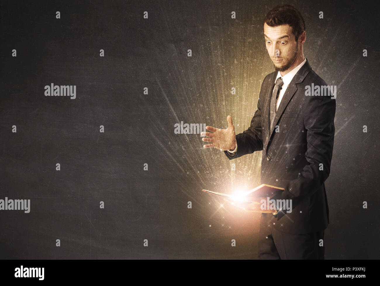 Man holding and reading a shiny book Stock Photo - Alamy