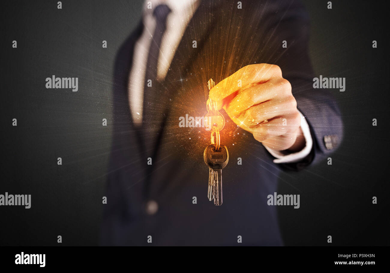 Formal man hand over shiny keys with dark background Stock Photo - Alamy