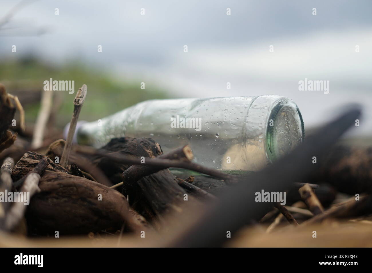 Glass bottles is dump into the sea, dirty waste on beach in summer day ...
