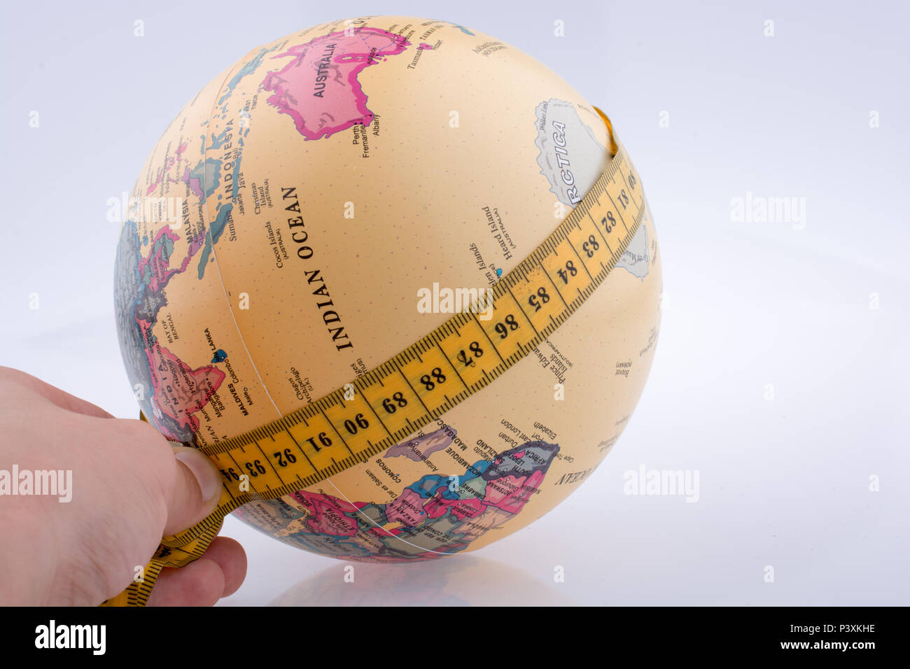 Child holding a measuring tape around globe on a white background Stock ...