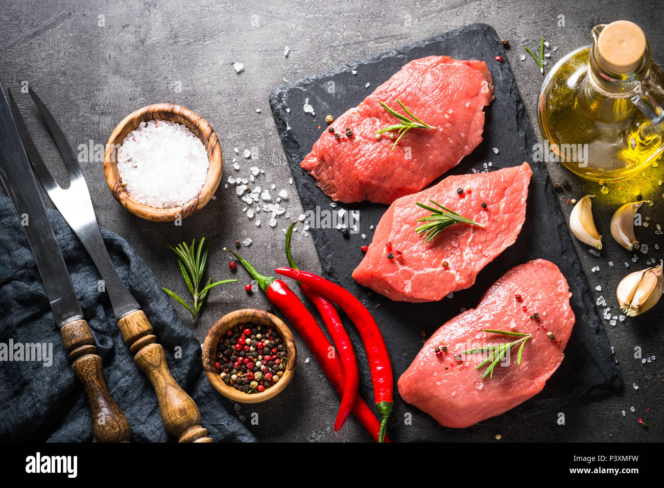 Raw meat. Fresh beef steak with rosemary and spices on black background ...