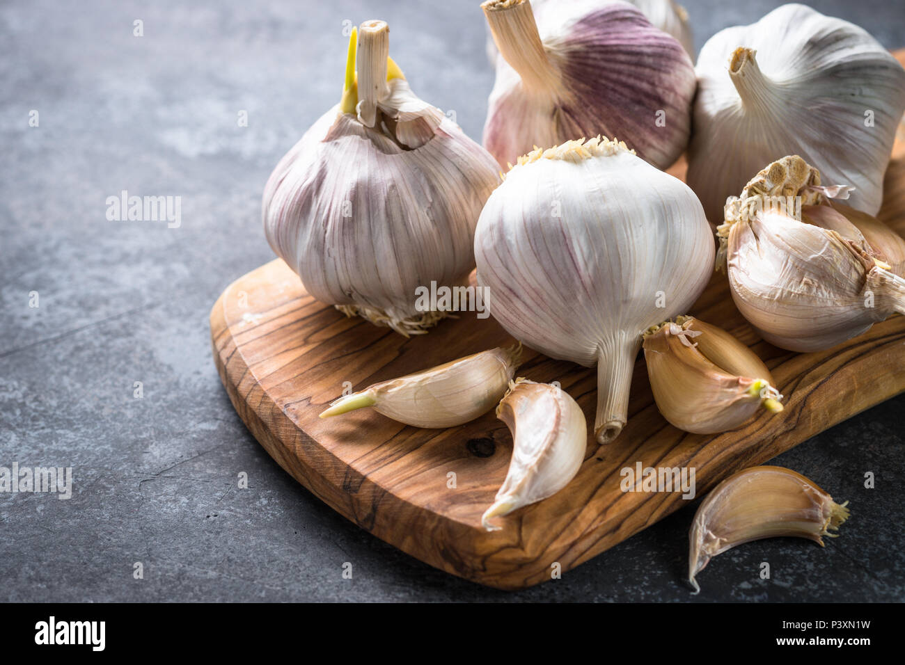 Garlic cloves on a dark stone background Stock Photo - Alamy