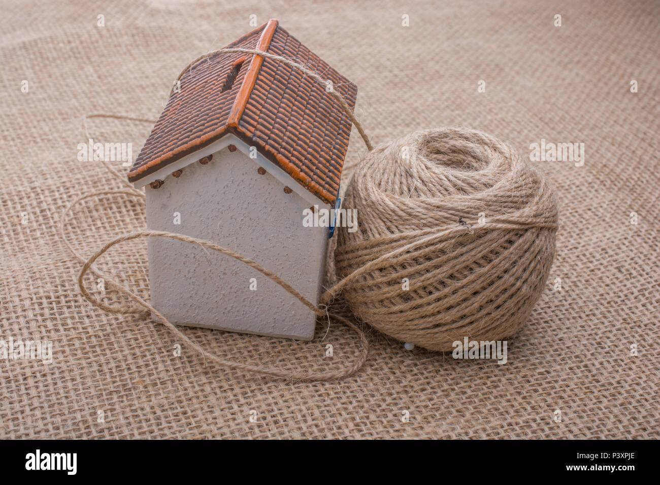 Thread wrapped around a model house on a brown background Stock Photo ...