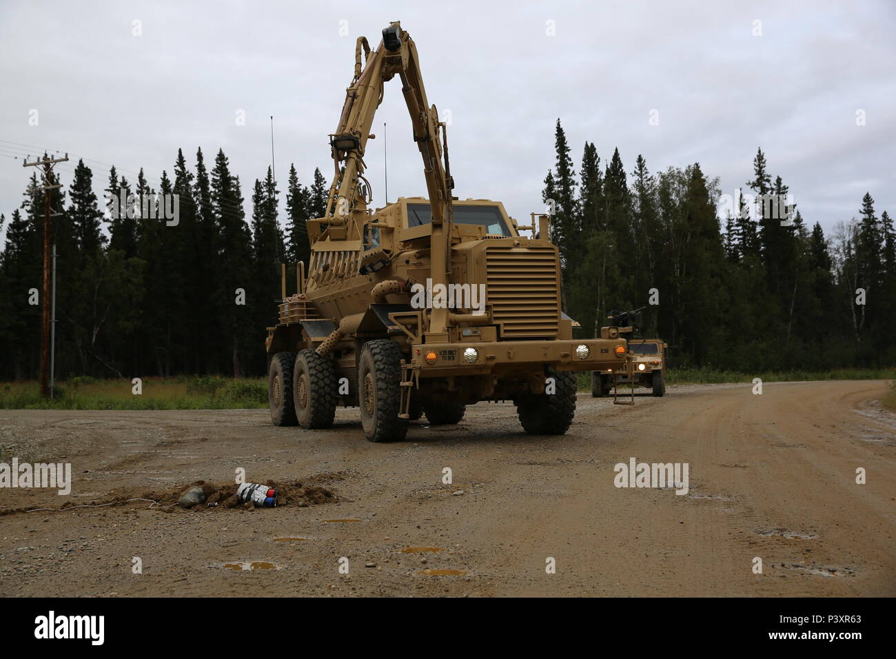 An Army Buffalo Mine-Protected Clearance Vehicle works to dig up a ...