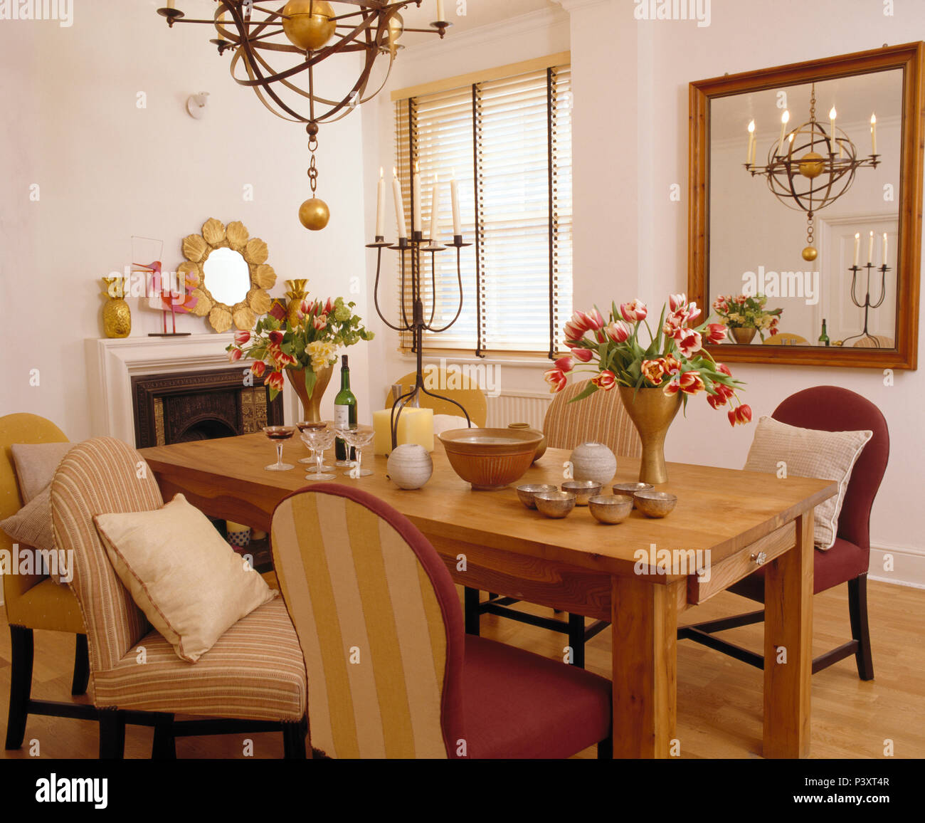 Gimbal style light fitting above simple wood table with upholstered ...