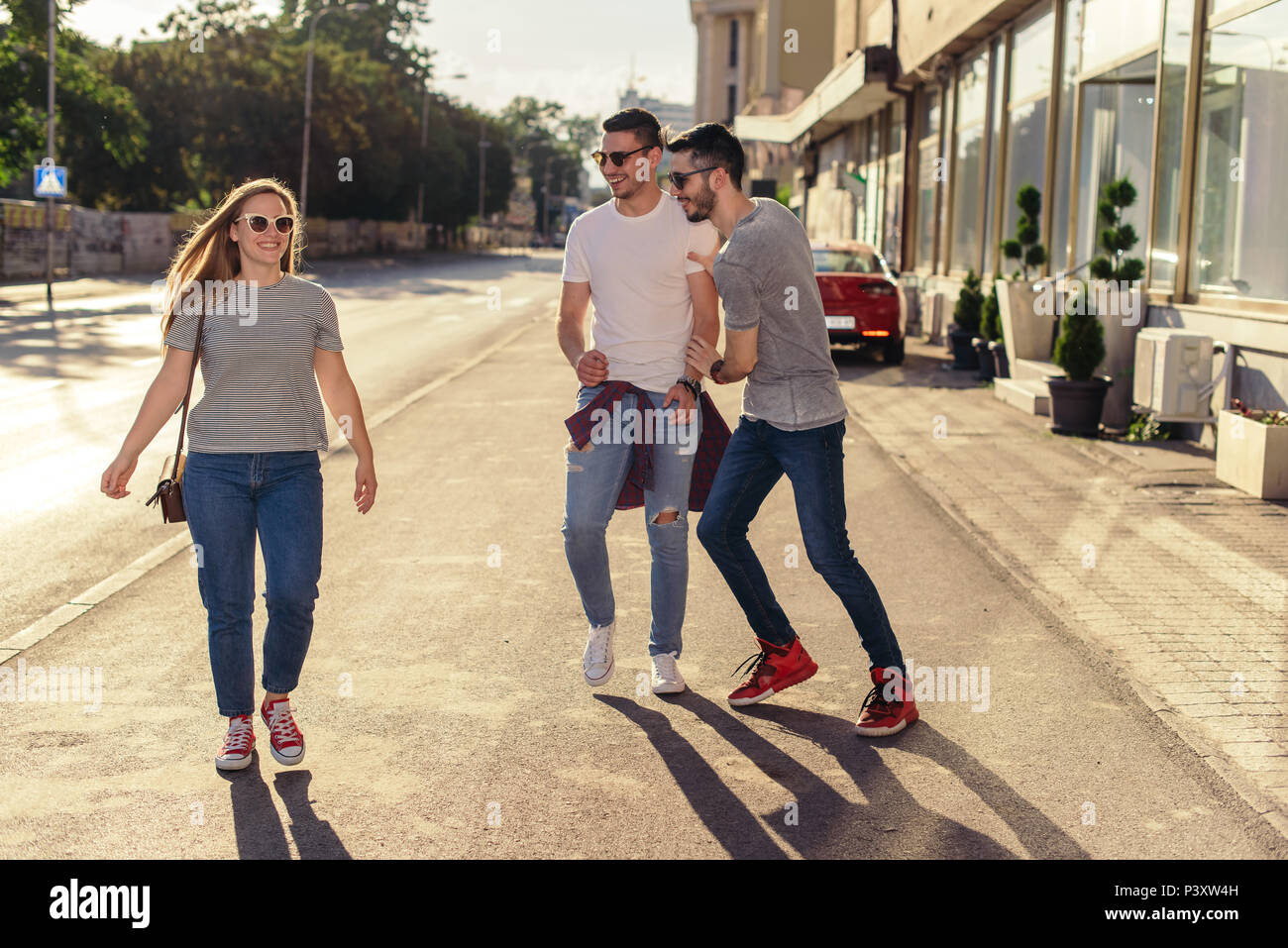 Group of young best friends having fun together walking on town street ...
