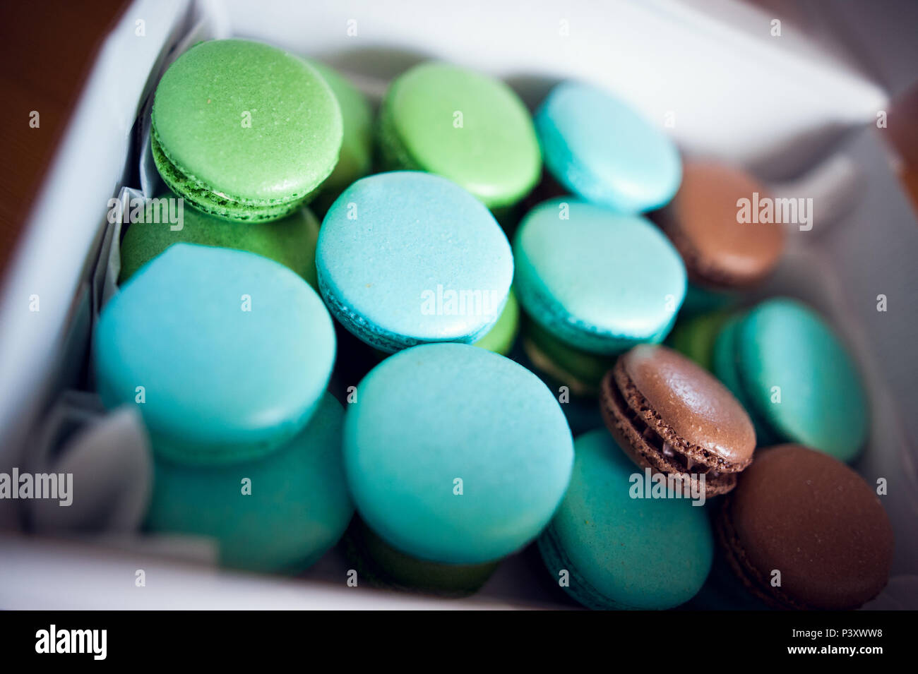 blue, green and chocolate macarons together in one box Stock Photo - Alamy
