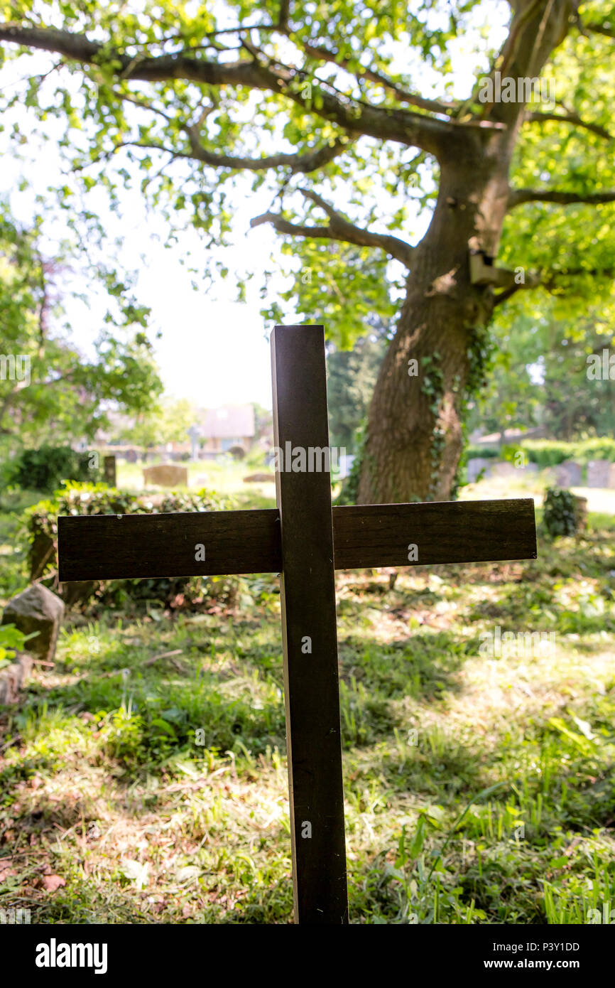 A quiet graveyard in the Uk with weathered cross in the grass Stock Photo - Alamy