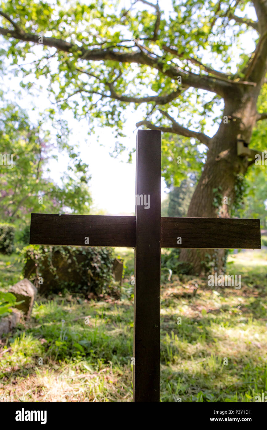 A quiet graveyard in the Uk with weathered cross in the grass Stock Photo - Alamy