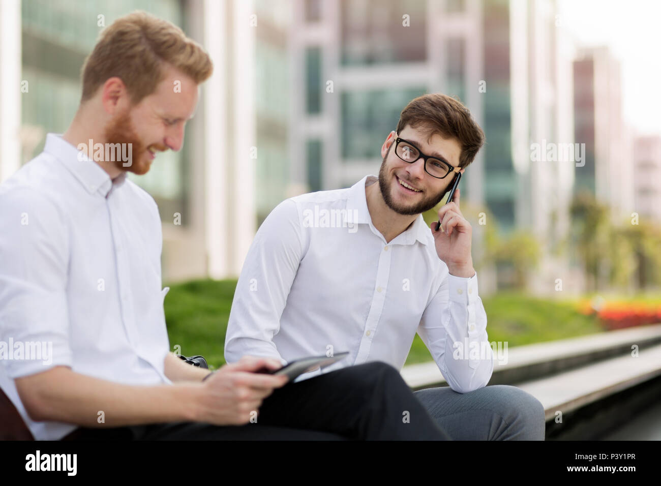 Business colleagues sitting on bench Stock Photo - Alamy