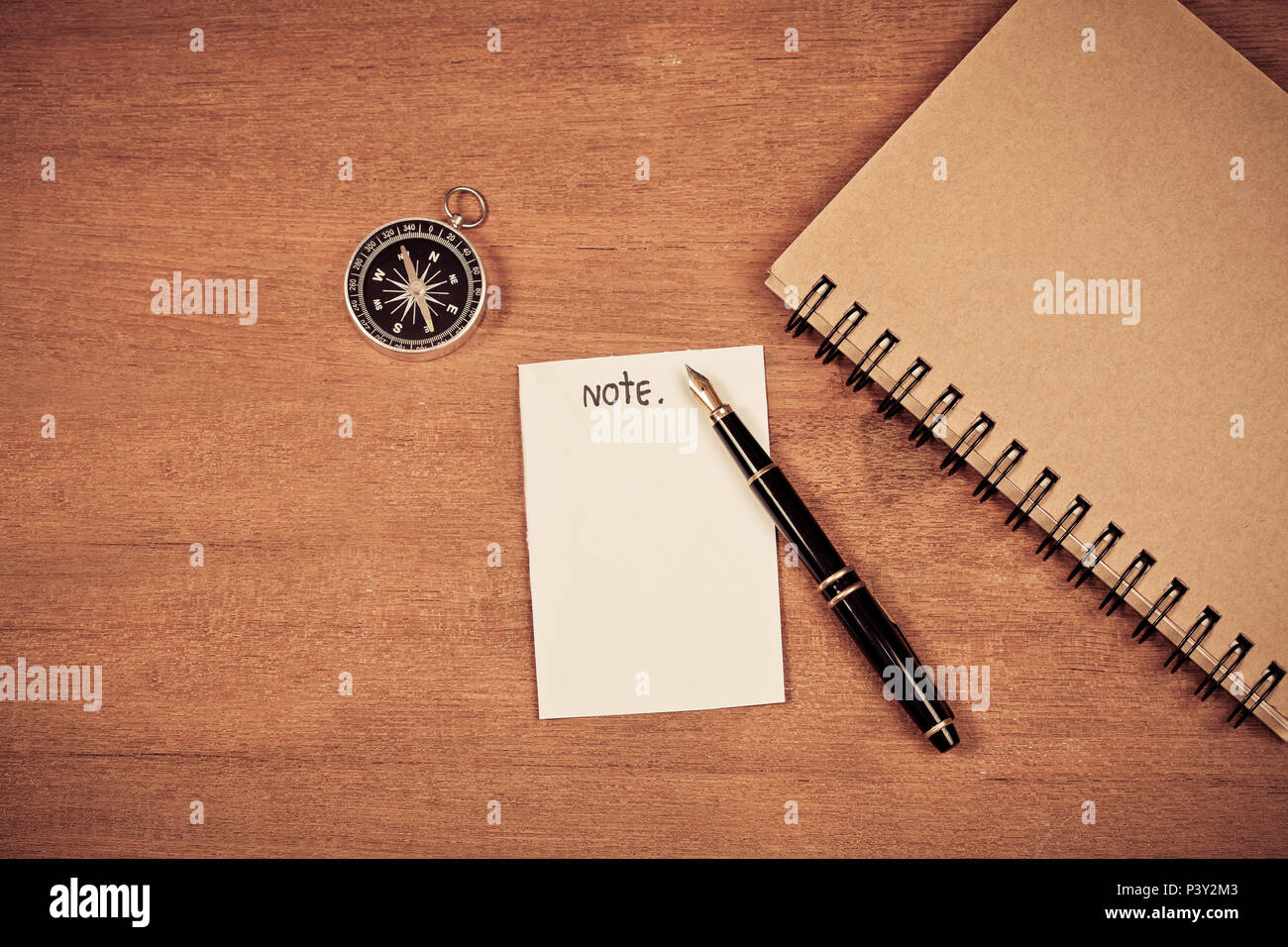 Paper note with vintage compass and dairy book on table Stock Photo - Alamy