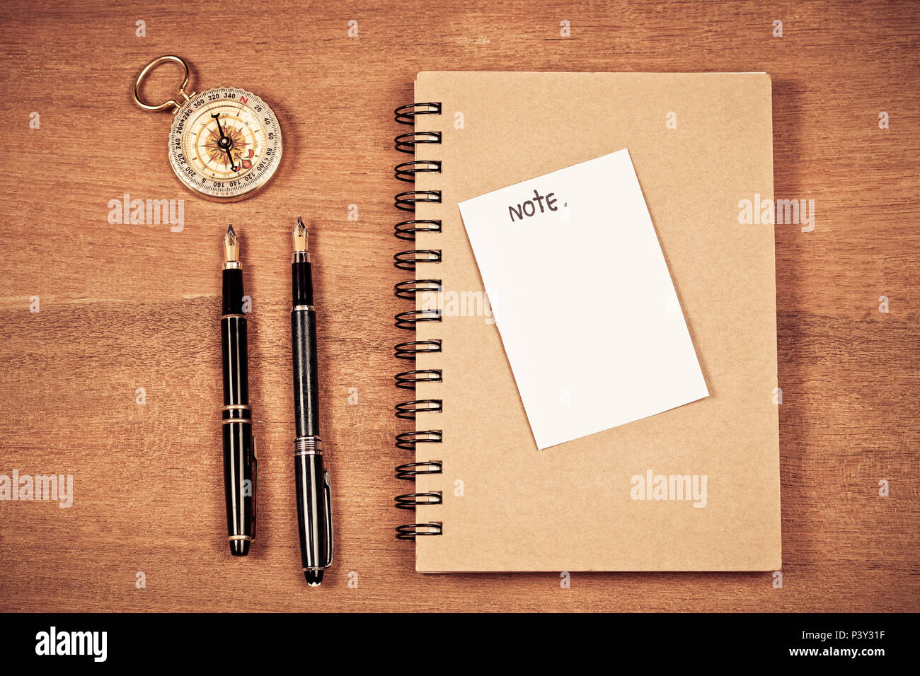 Paper note with vintage compass and dairy book on table Stock Photo - Alamy