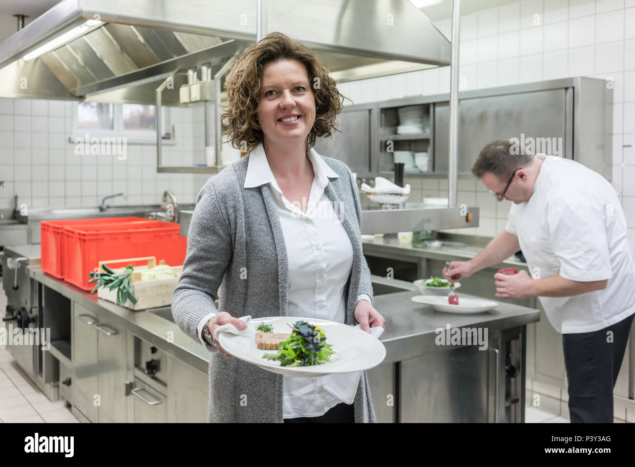 Service waitress in restaurant getting dish from pass in kitchen Stock ...