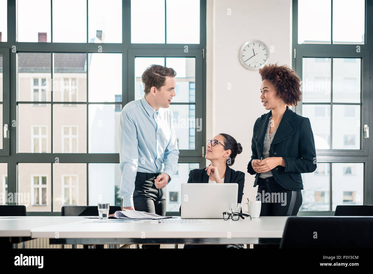 Three young colleagues talking during break in the meeting room Stock ...